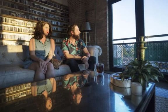 two people sitting on a couch in a living room