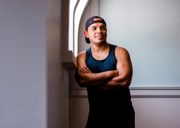 a man standing by a window with his arms crossed