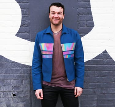 a man standing in front of a blue wall